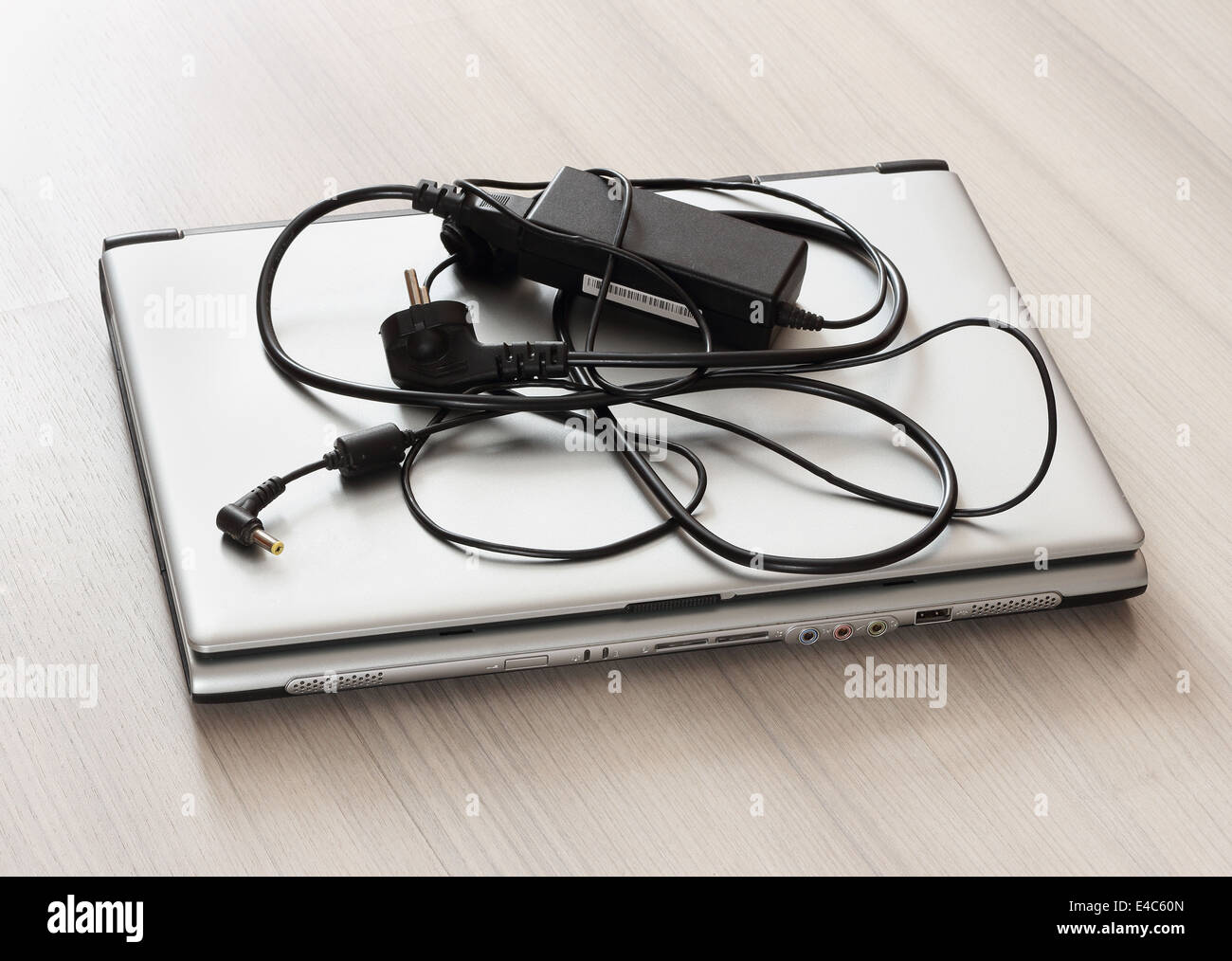 Closed laptop, on a light table with wires Stock Photo - Alamy
