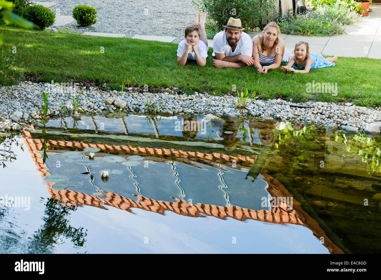Family with two children takes a break by the pond, Munich, Bavaria ...