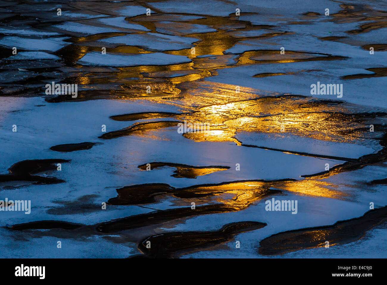 Light of winter sunset reflects in the ice of the frozen river Stock ...