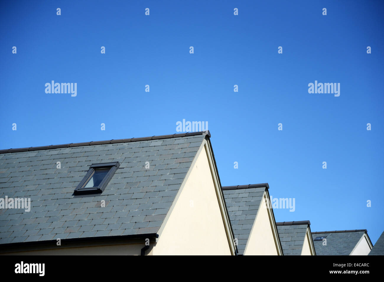 Blues skies over new build homes roof tops Stock Photo - Alamy