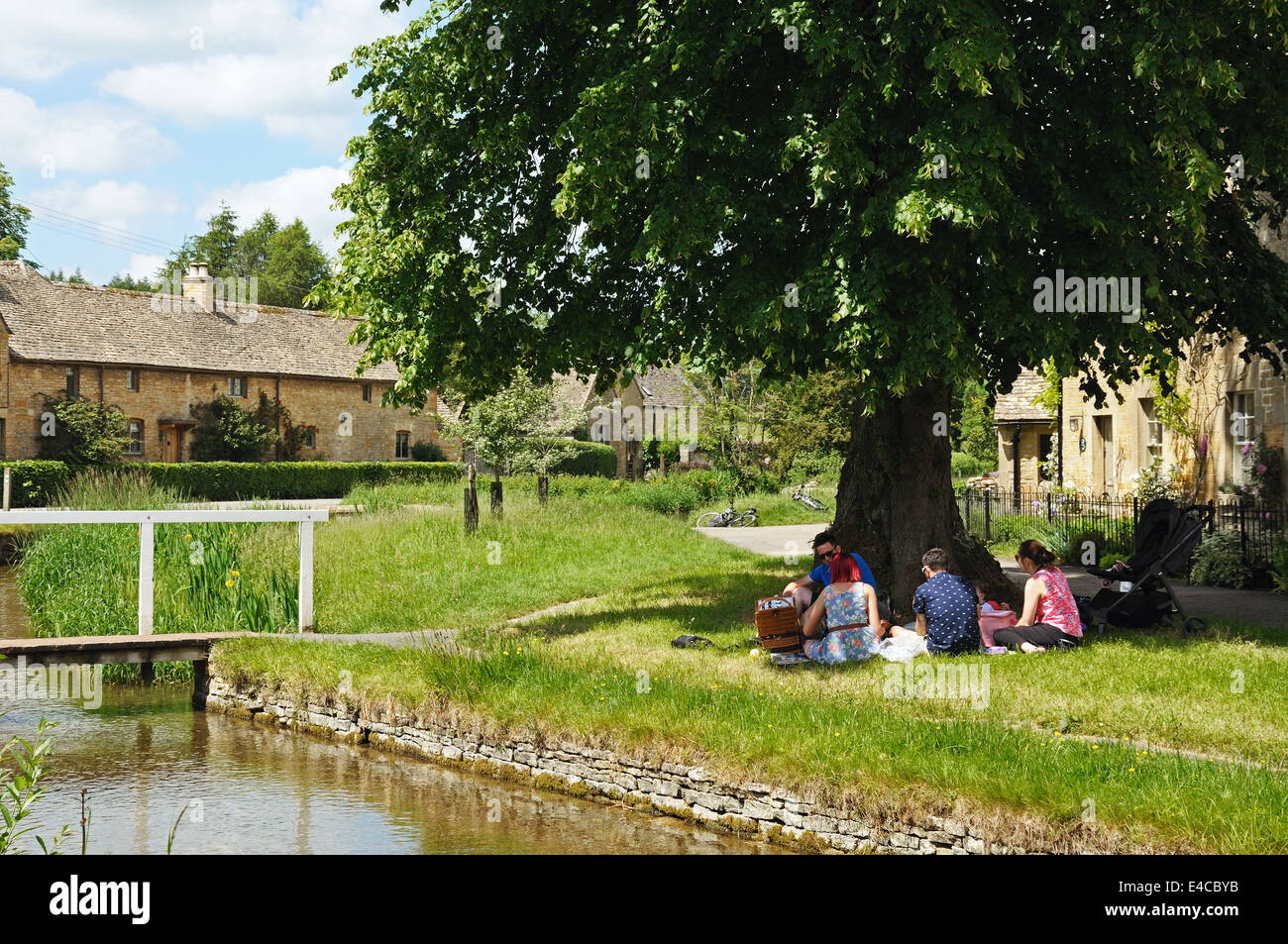 People sitting under a tree having a picnic along the river Eye in the ...