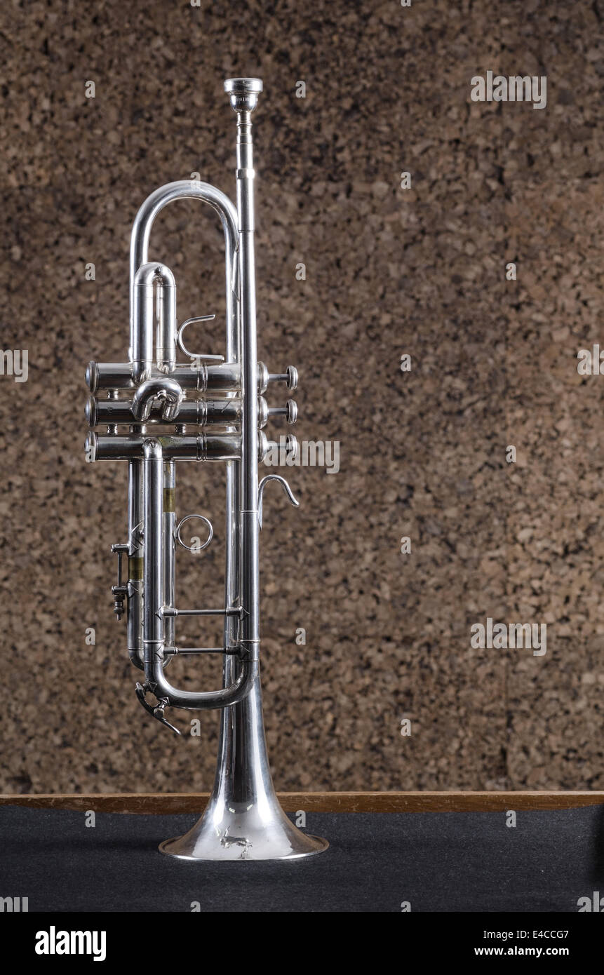 A silver trumpet against the background of a cork cladded studio wall ...
