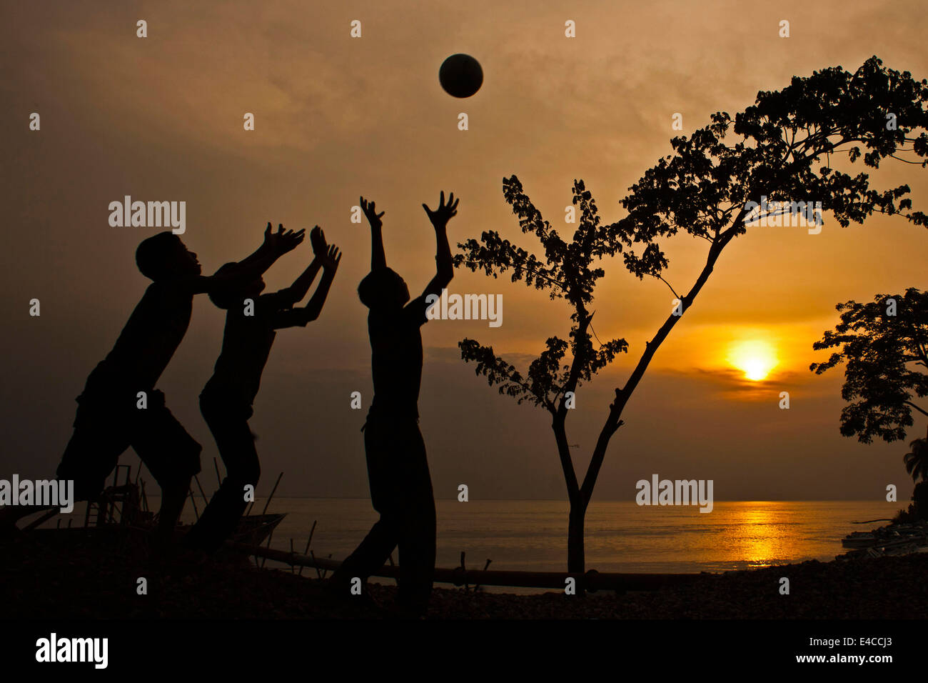 children are playing football during sunset Stock Photo - Alamy