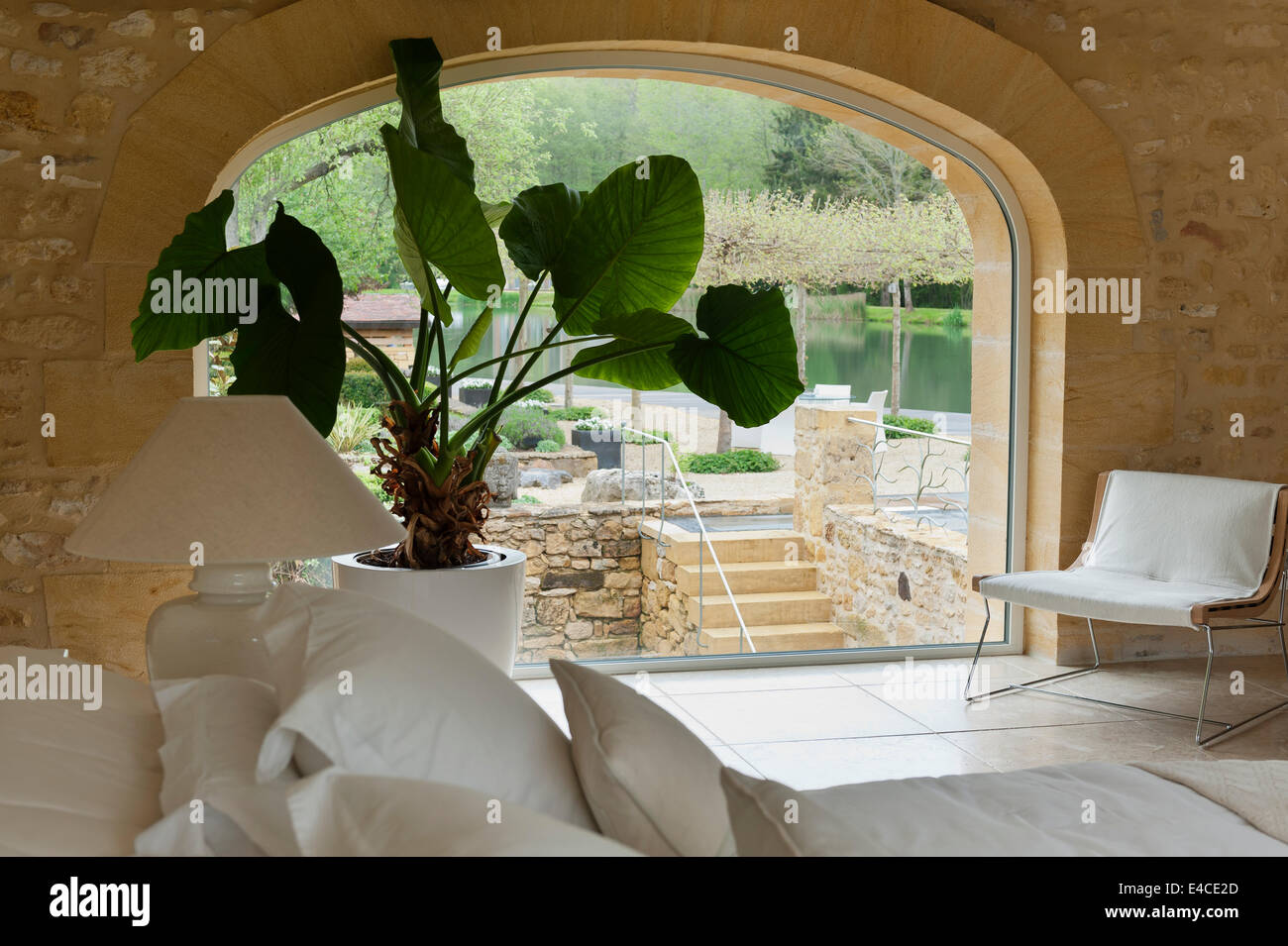 Large arched window with outlook to garden and lake. The white chair is ...