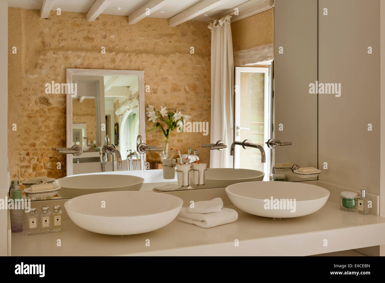 Twin Spoon CER 700 basins by Agape in bathroom with rough stone walls ...