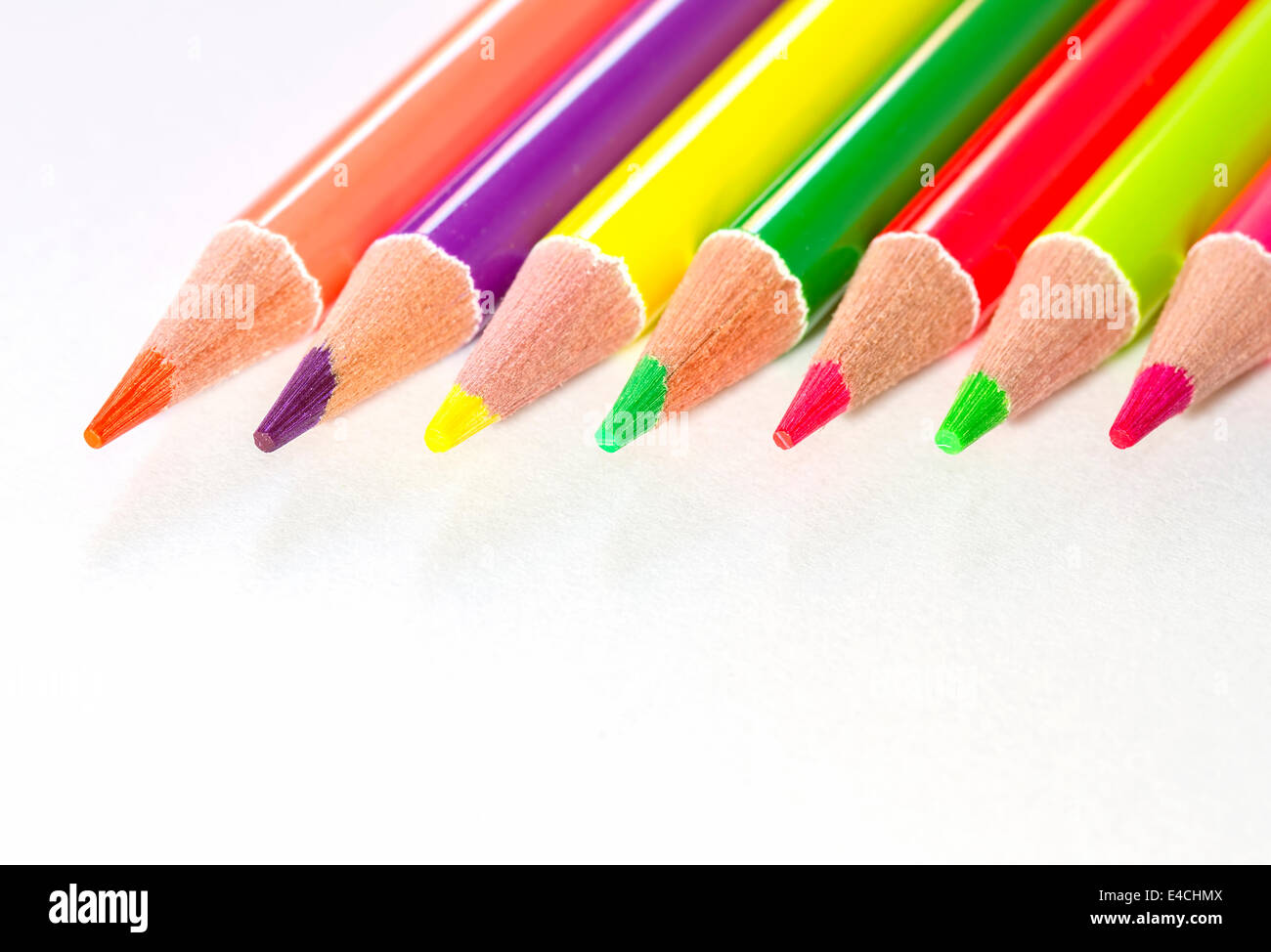 Row of color pencils on white paper Stock Photo - Alamy