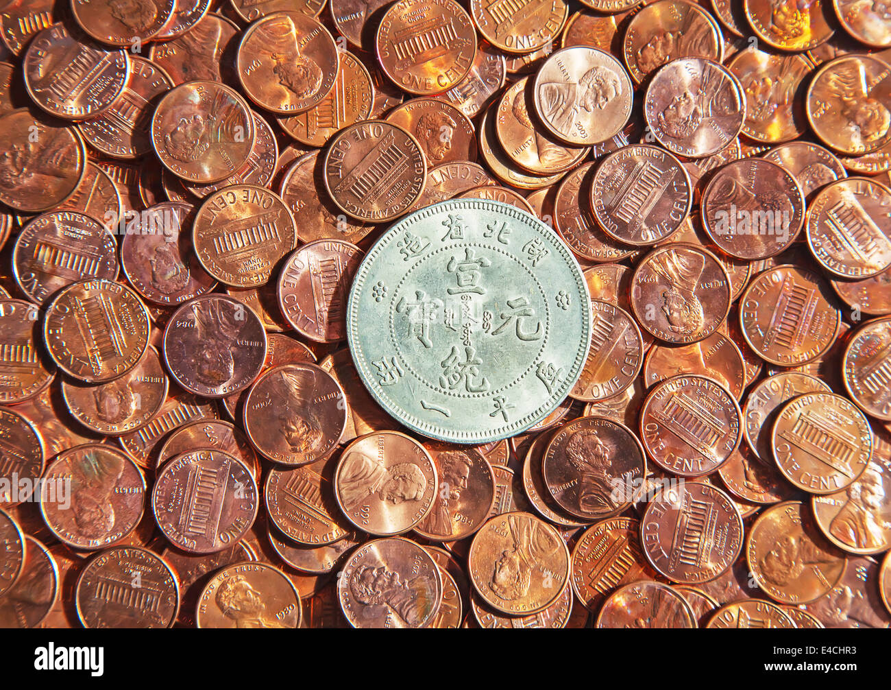 Chinese silver coin over pile of the US coins Stock Photo - Alamy