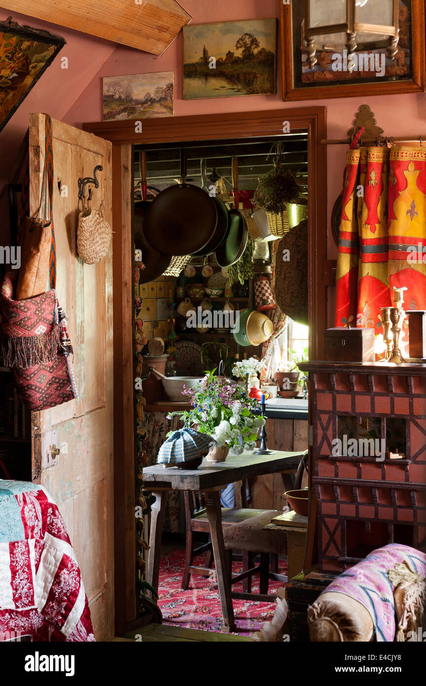 View through open cottage door through to cluttered country kitchen ...