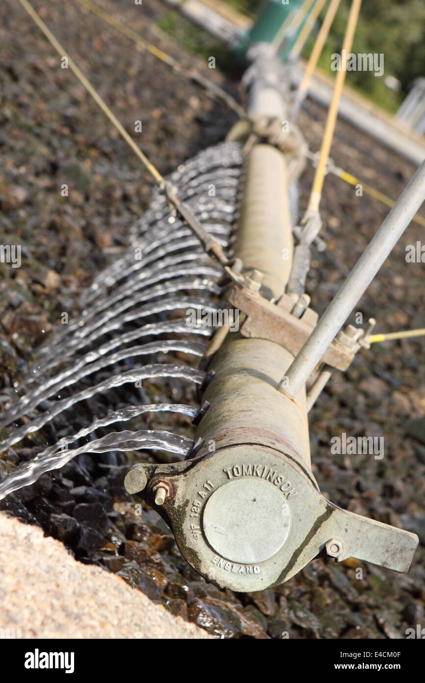 Sewage treatment plant works the rotating arm pours sewage over the ...