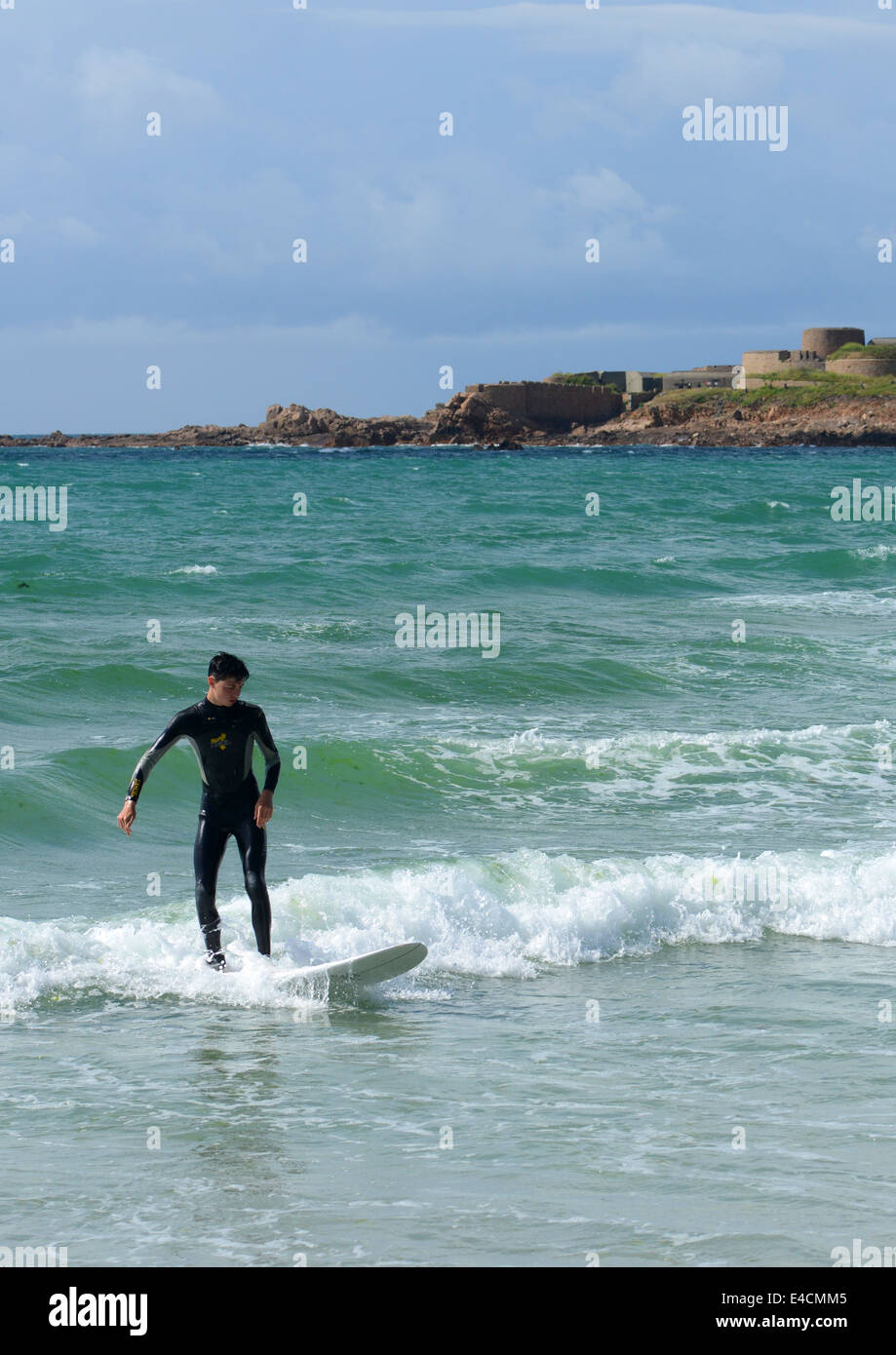 Teenage surfer riding the waves at Vazon Bay in Guernsey, Channel ...
