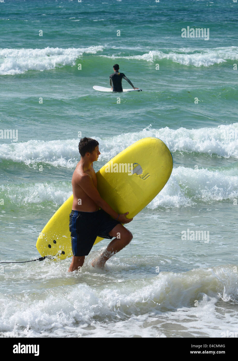 Surfer emerging from the sea holding surf board Stock Photo - Alamy