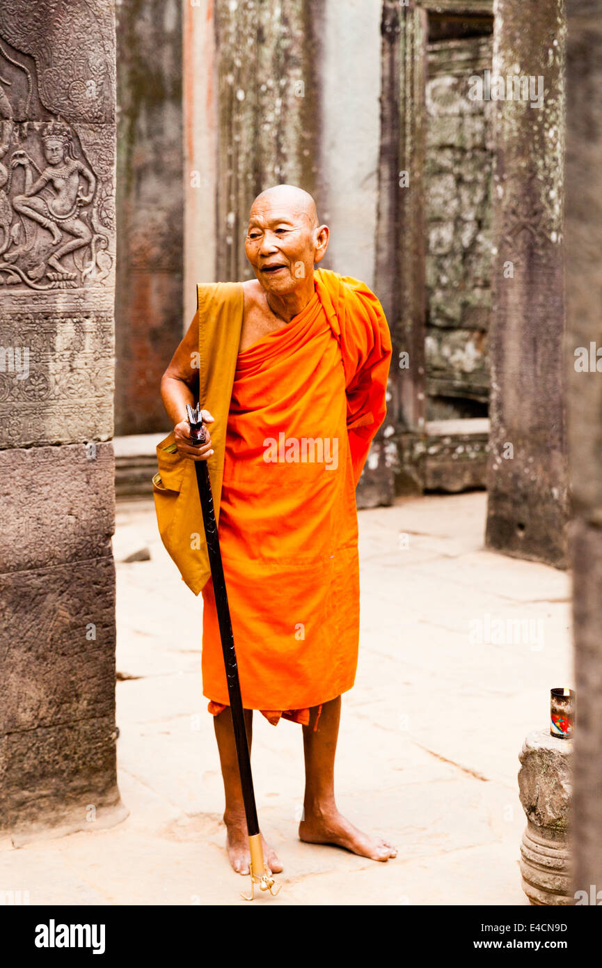 Elderly monk with walking stick, Bayon temple, Angkor temple complex ...