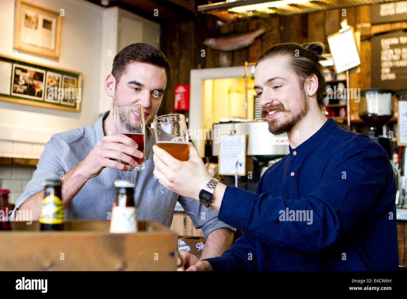 Young men toasting with beer in pub, Dorset, Bournemouth, England Stock ...