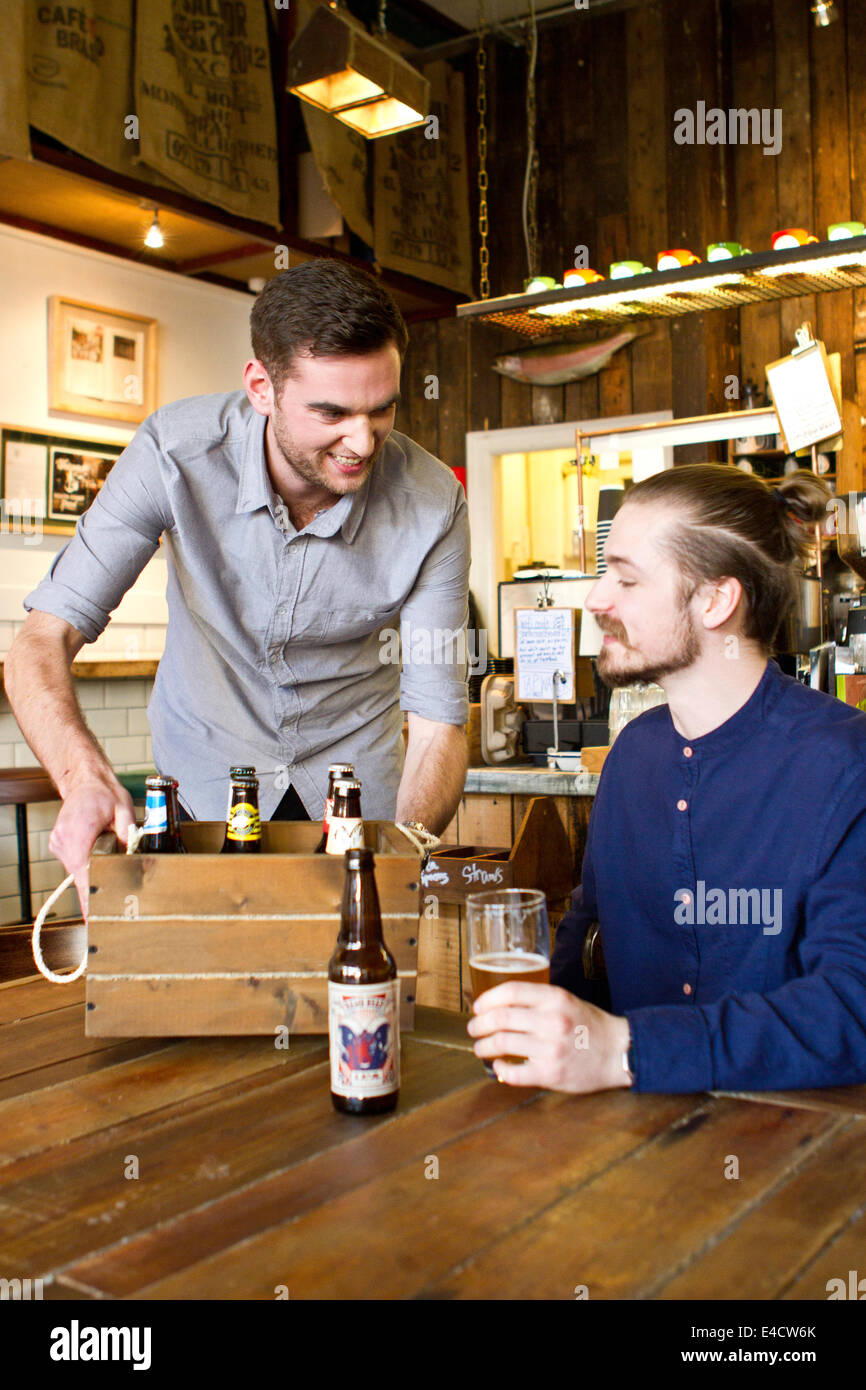Young man showing variety of beers to friend in pub, Dorset ...