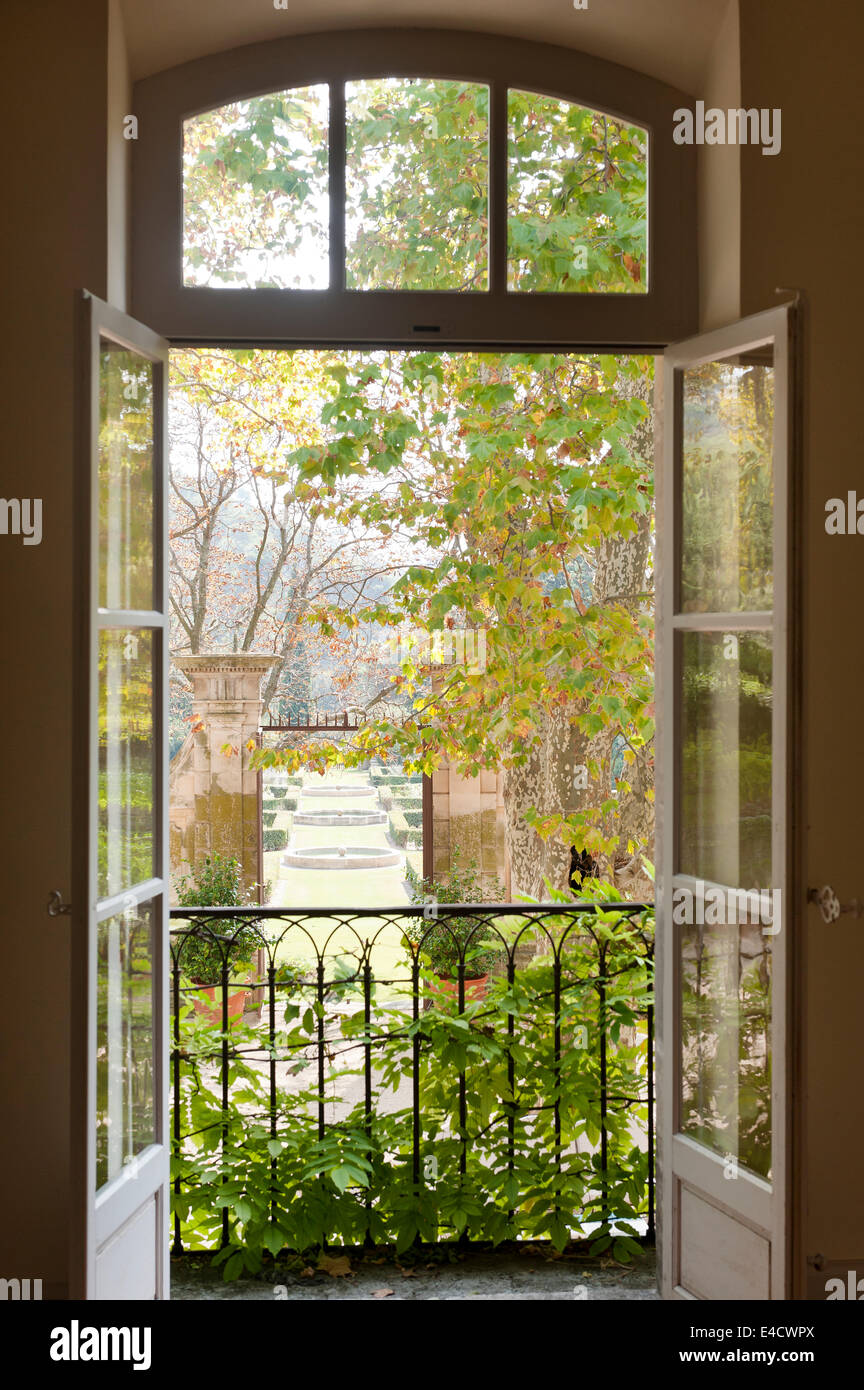 View through open windows out to garden with topiary and fountains ...