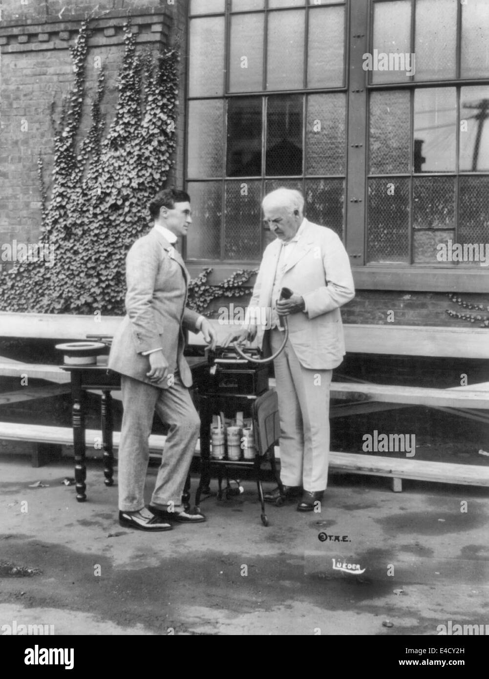Thomas Alva Edison standing, facing left, with one of his inventions ...