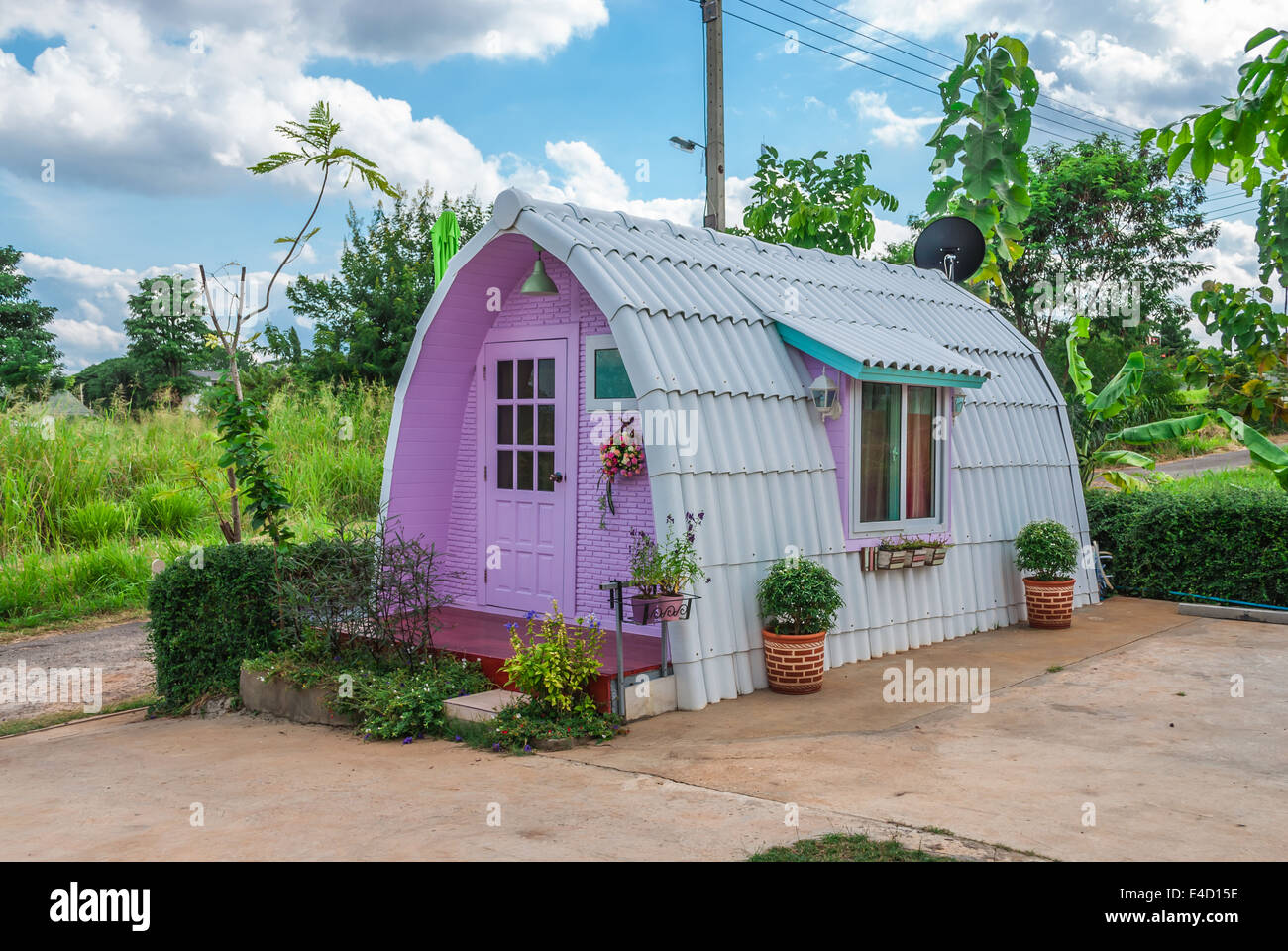 Cute Small Purple Cottage with Wave Roof Stock Photo - Alamy