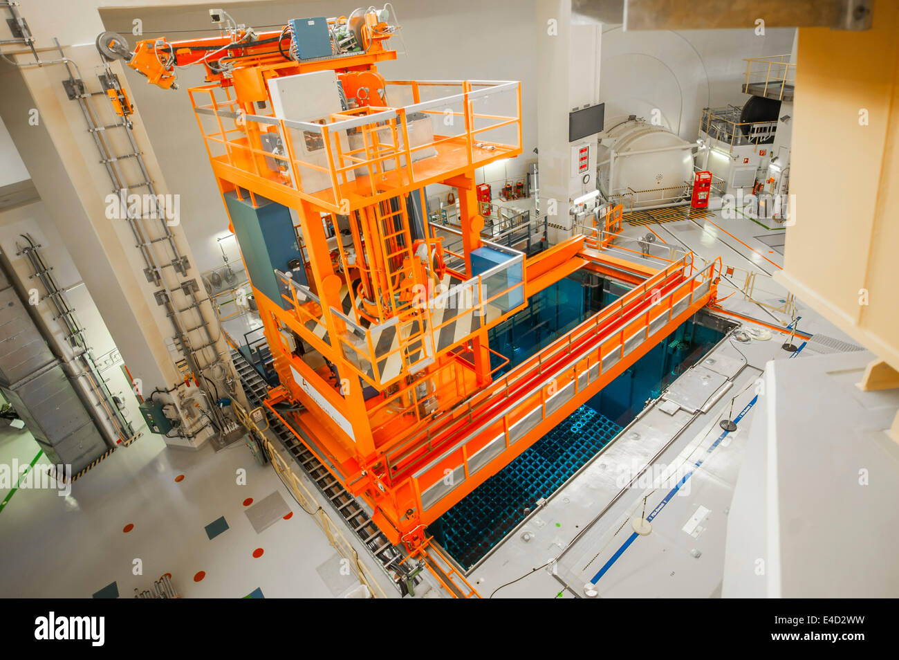 A crane above a cooling pond for spent fuel rods below the reactor dome ...