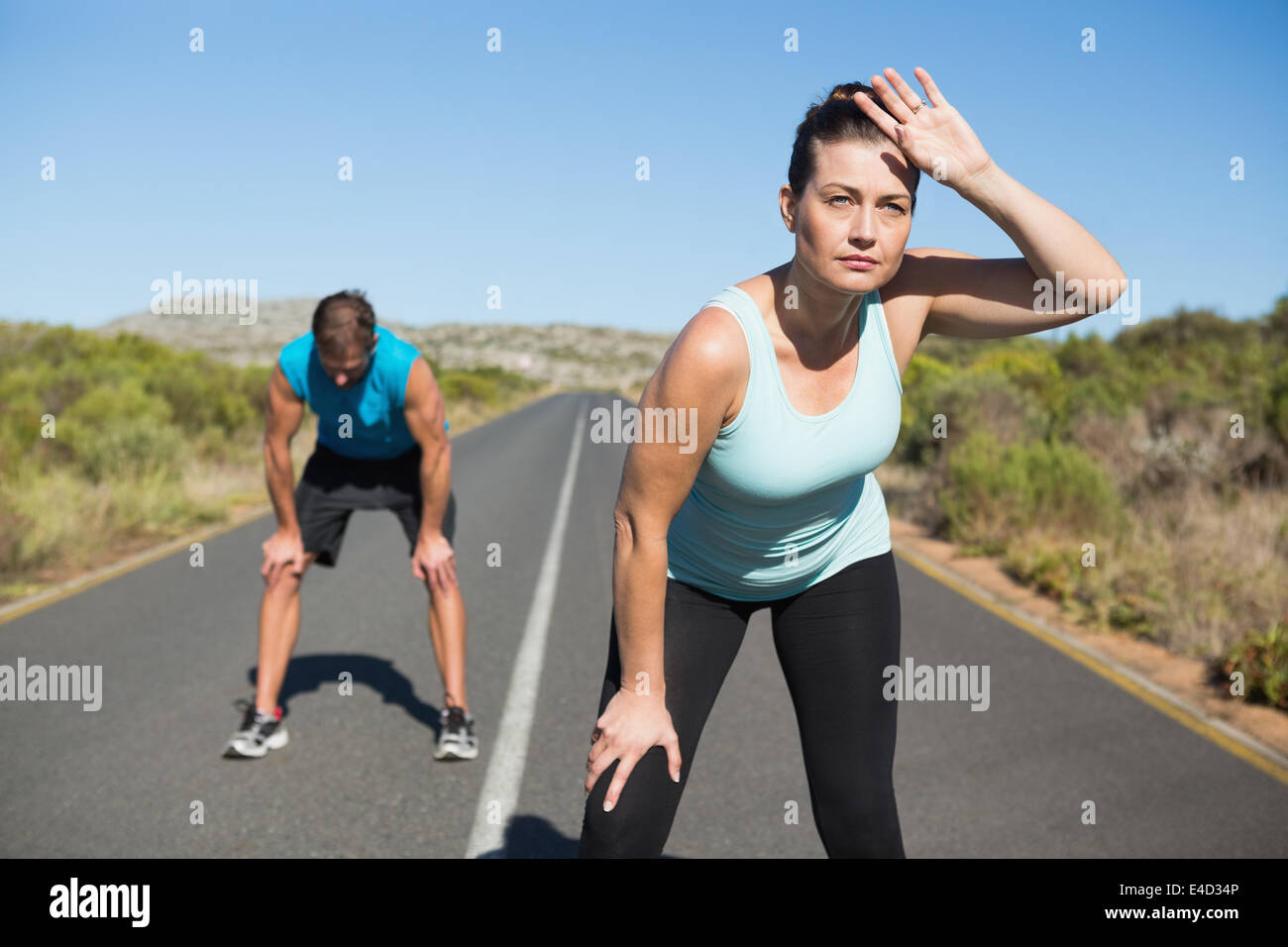 Fit couple jogging on the open road together Stock Photo - Alamy