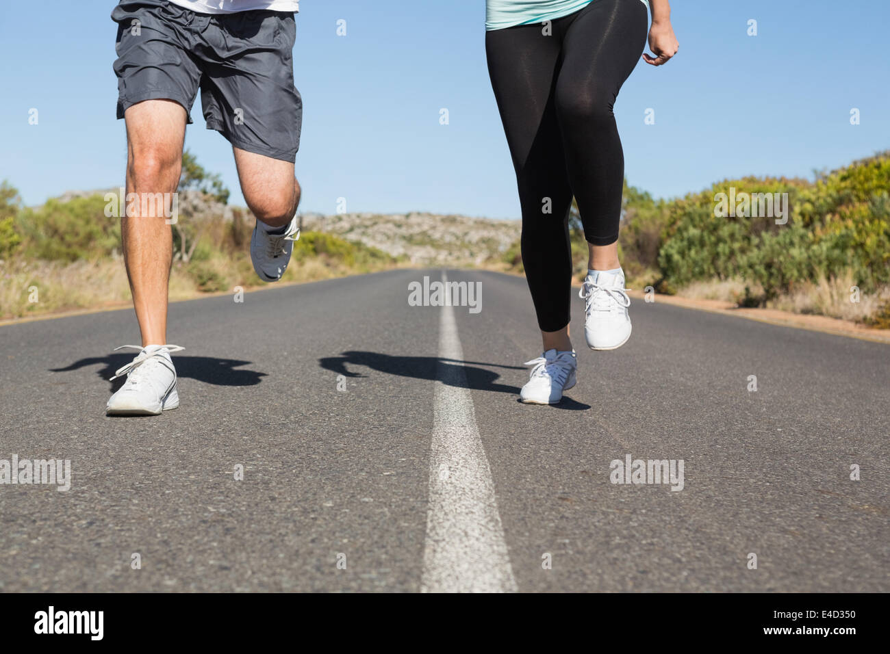 Fit couple running on the open road together Stock Photo - Alamy