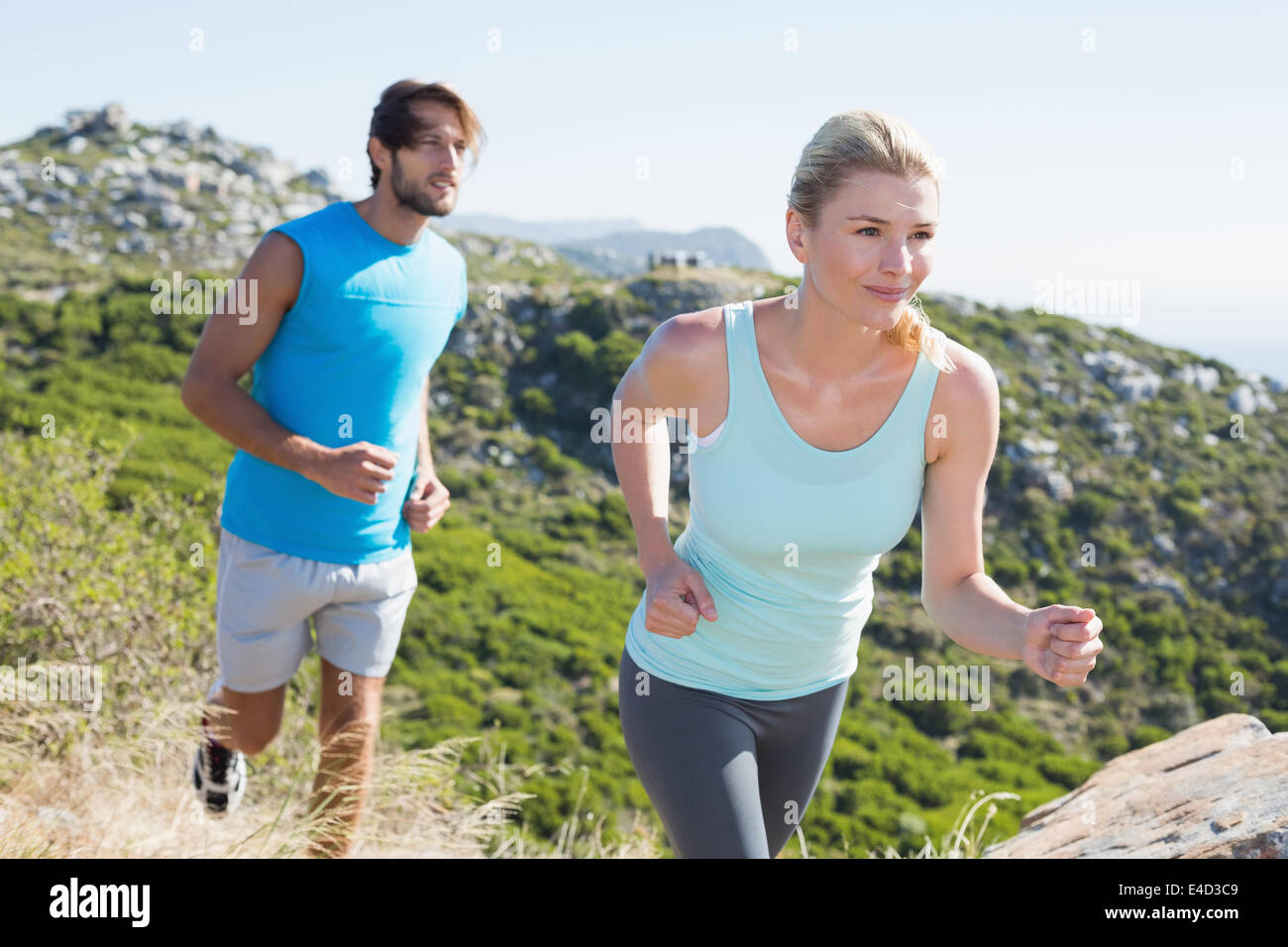 Fit couple jogging through countryside Stock Photo - Alamy