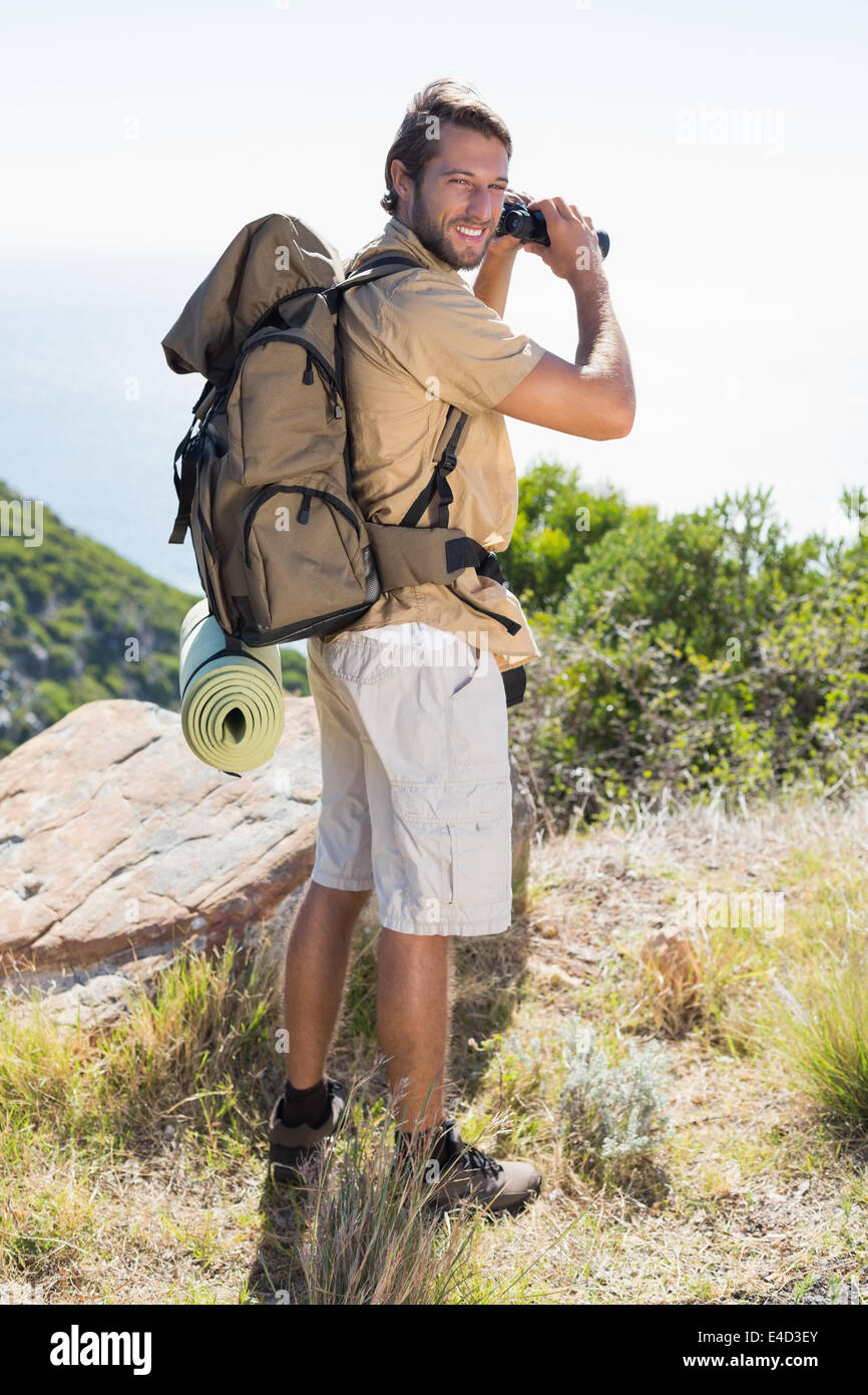 Handsome hiker looking through binoculars Stock Photo - Alamy