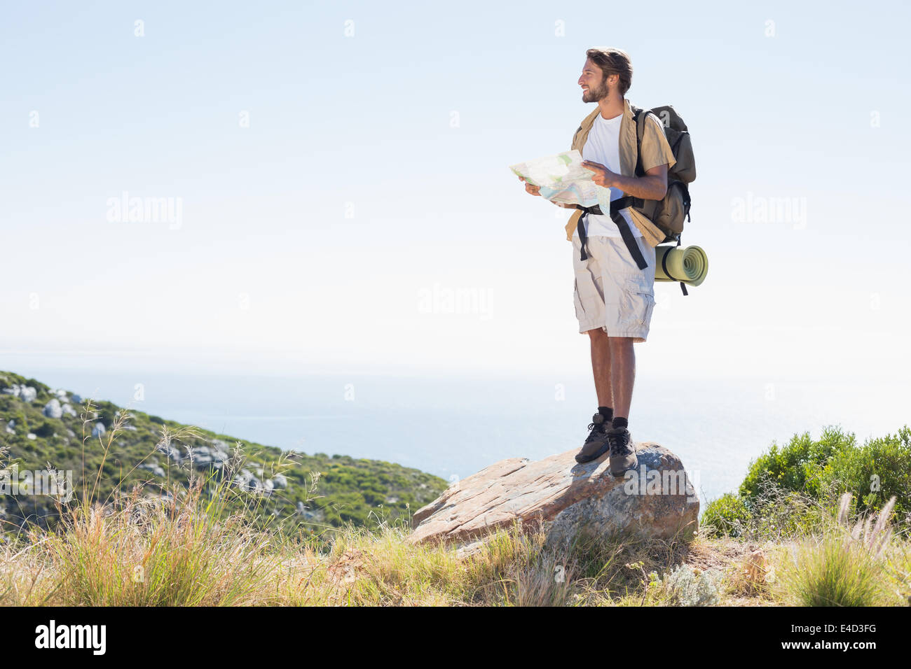 Handsome hiker holding map at mountain summit Stock Photo - Alamy