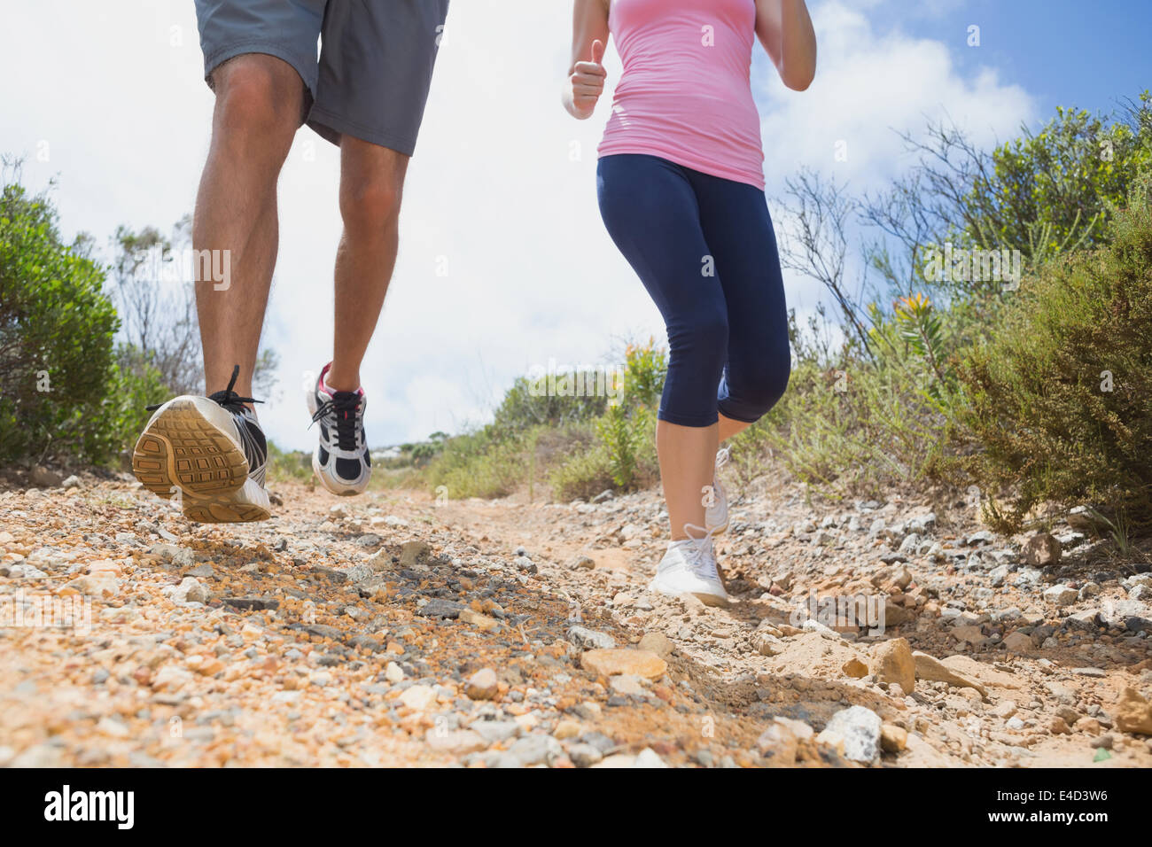 Fit couple running down mountain trail Stock Photo - Alamy