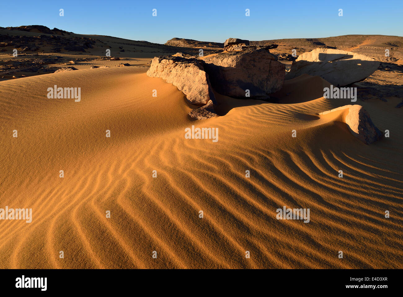 Sand dunes and sandblasted rocks on Tadrart plateau, Tassili n'Ajjer ...