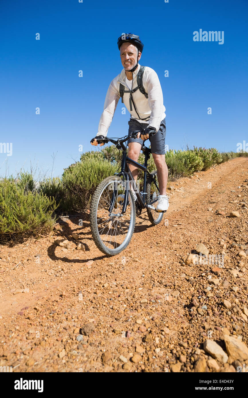 Fit cyclist cycling on country terrain Stock Photo - Alamy