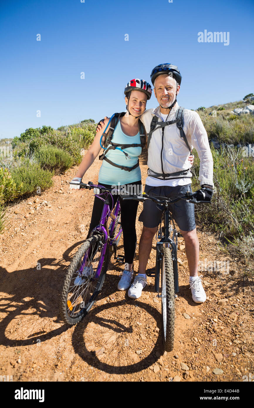 Active couple embracing on a bike ride in the country Stock Photo - Alamy