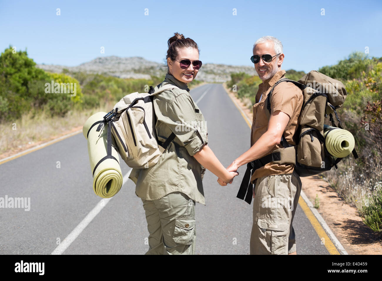 Hitch hiking couple standing holding hands on the road Stock Photo - Alamy