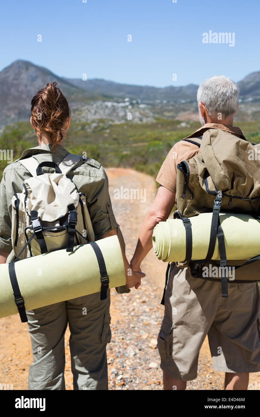 Hiking couple standing on mountain trail holding hands Stock Photo - Alamy