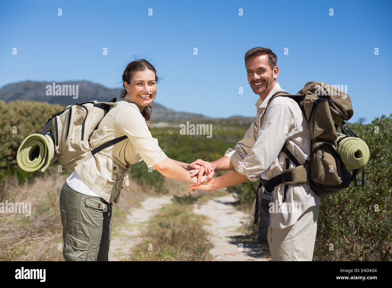 Hiking couple putting hands together on country trail Stock Photo - Alamy