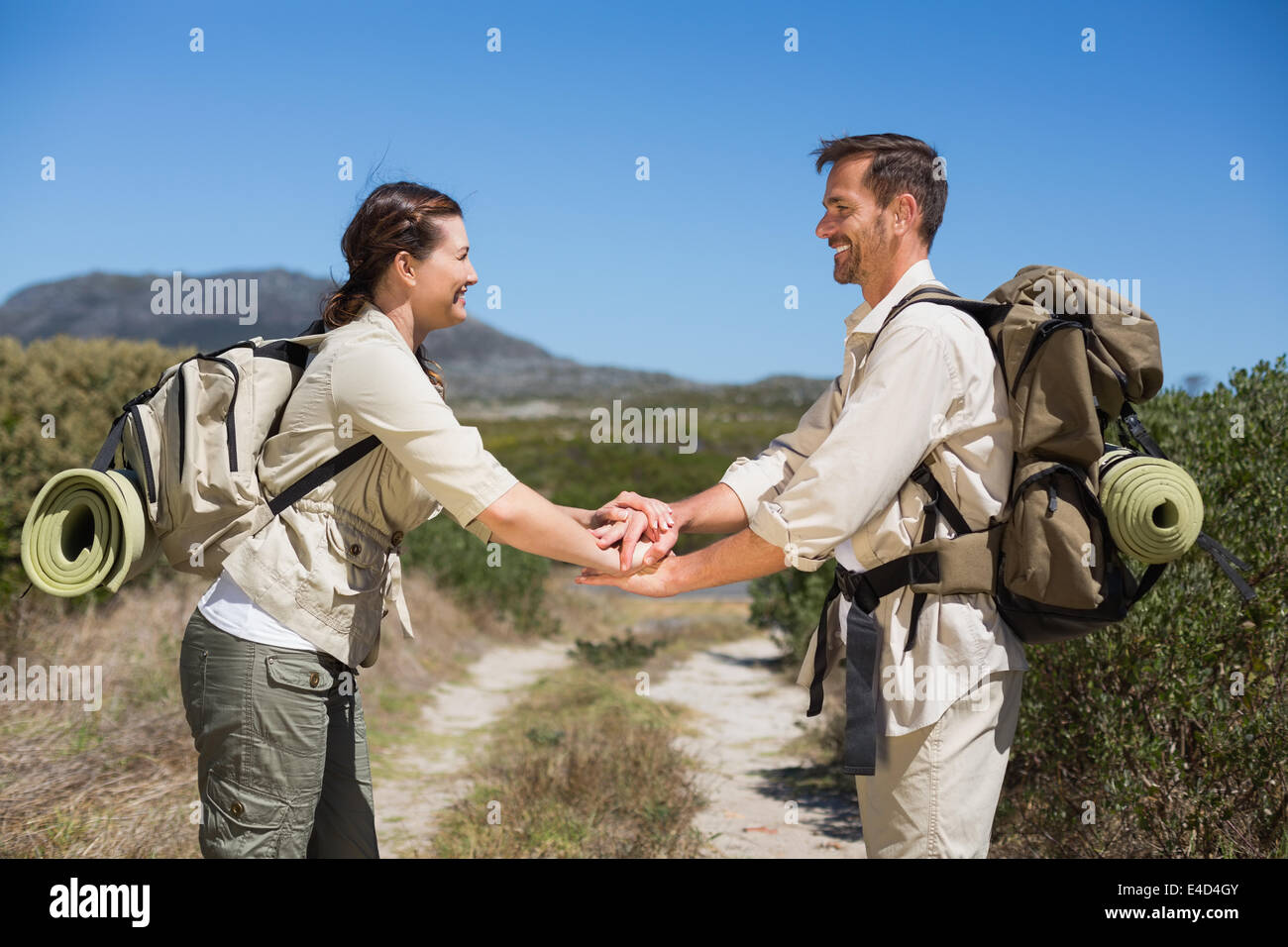 Hiking couple putting hands together on country trail Stock Photo - Alamy