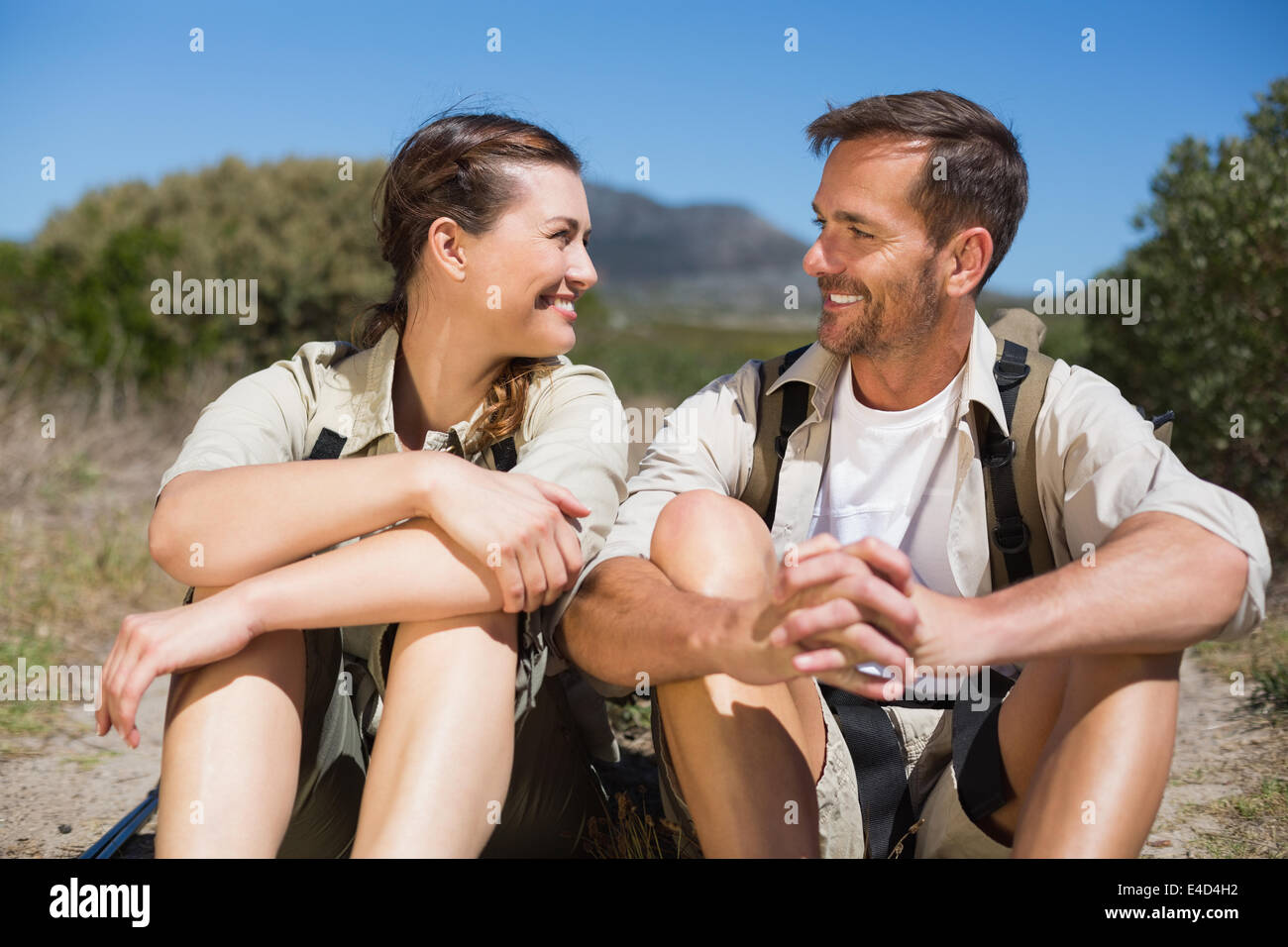 Hiking couple taking a break on country terrain Stock Photo - Alamy