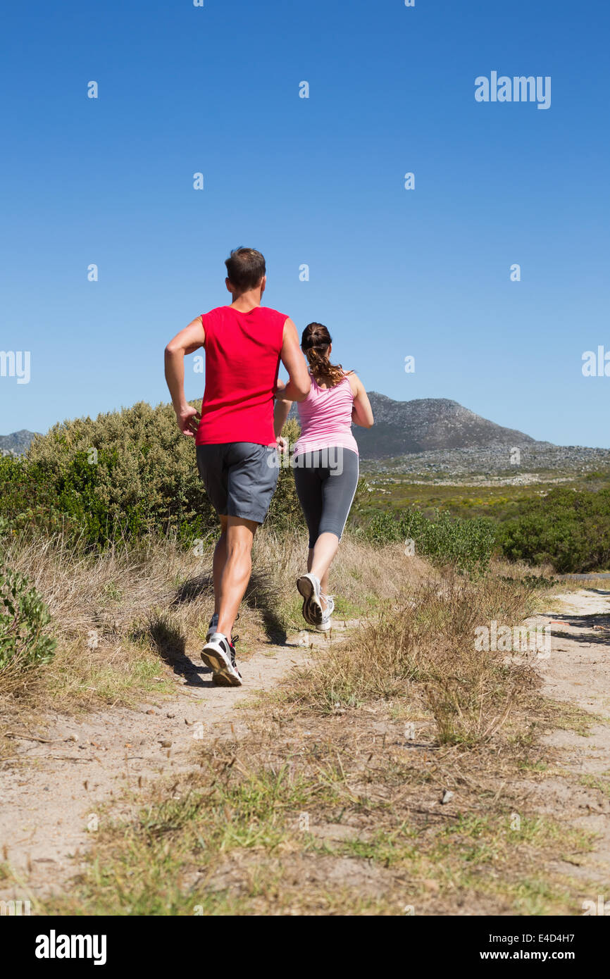 Active couple jogging on country terrain Stock Photo - Alamy