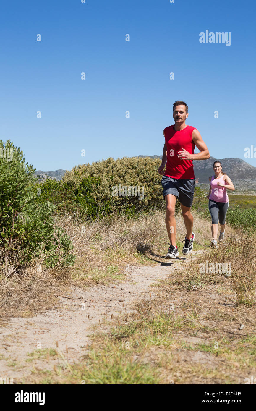 Active couple jogging on country terrain Stock Photo - Alamy