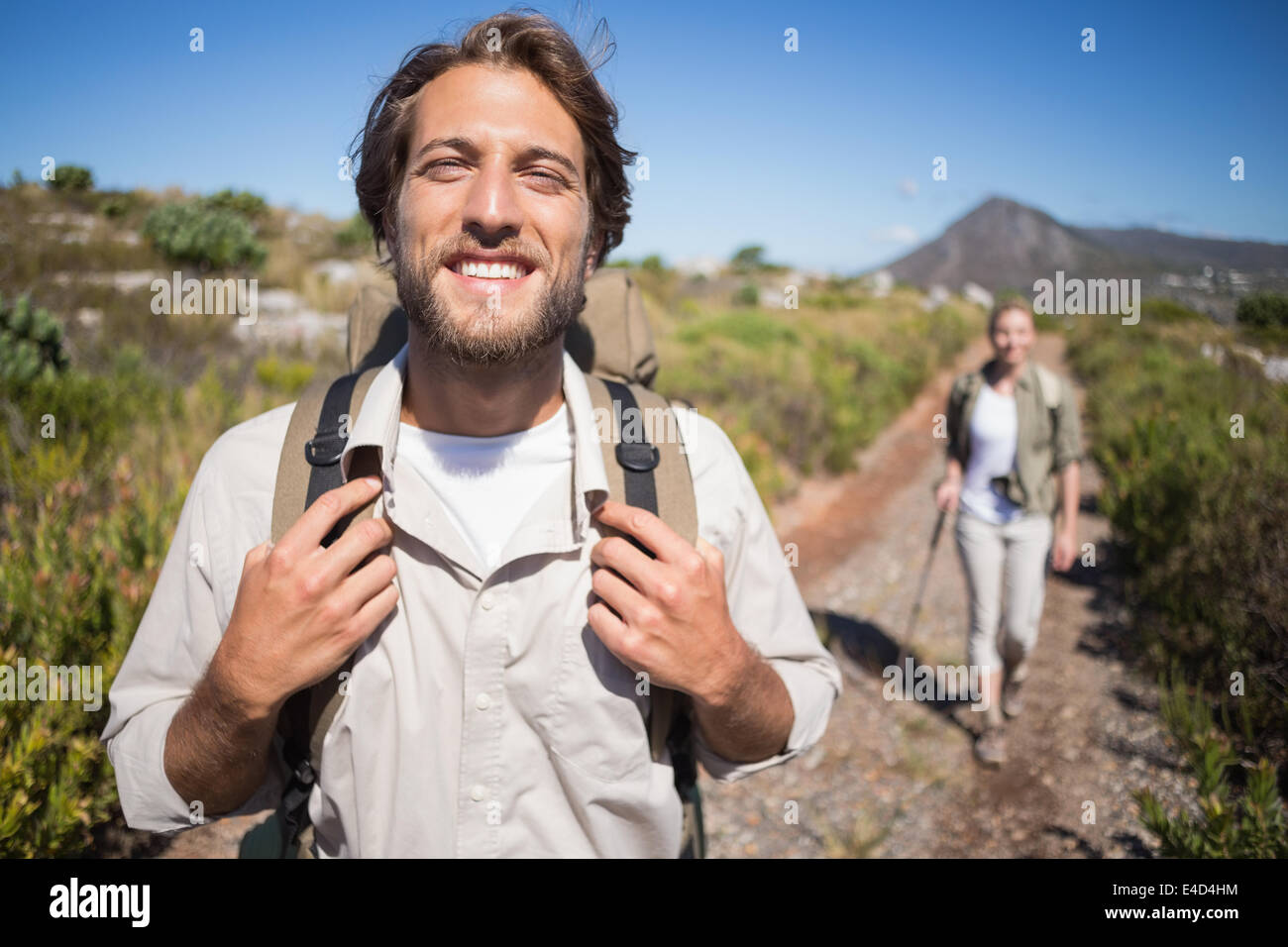 Happy hiking couple walking on mountain terrain Stock Photo - Alamy
