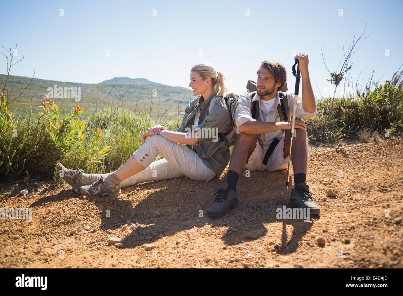 Hiking couple taking a break on mountain terrain Stock Photo - Alamy