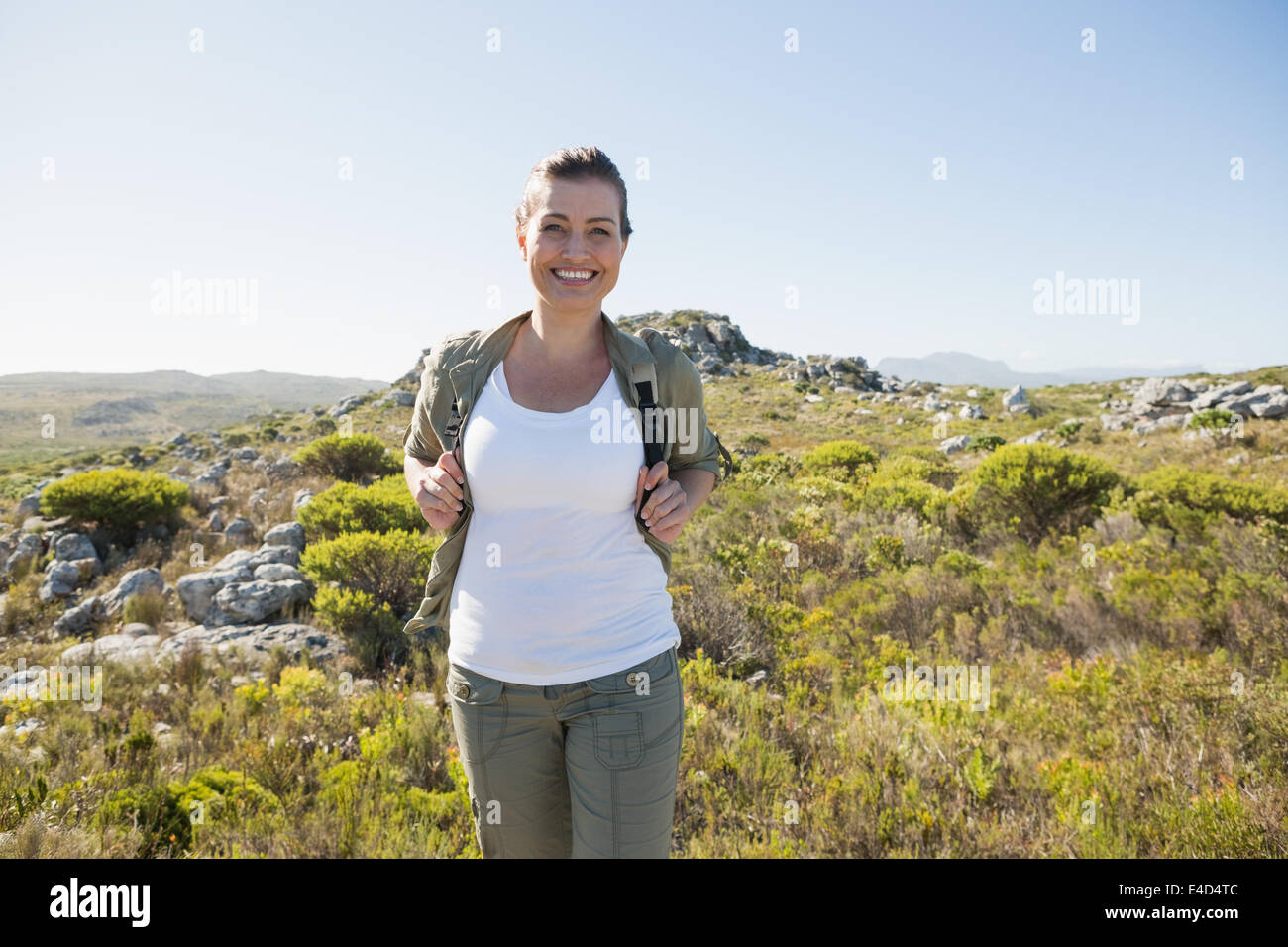 Pretty hiker smiling at camera on mountain terrain Stock Photo - Alamy