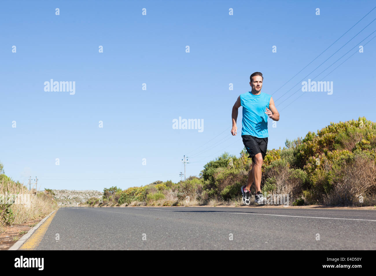 Athletic man jogging on the open road Stock Photo - Alamy