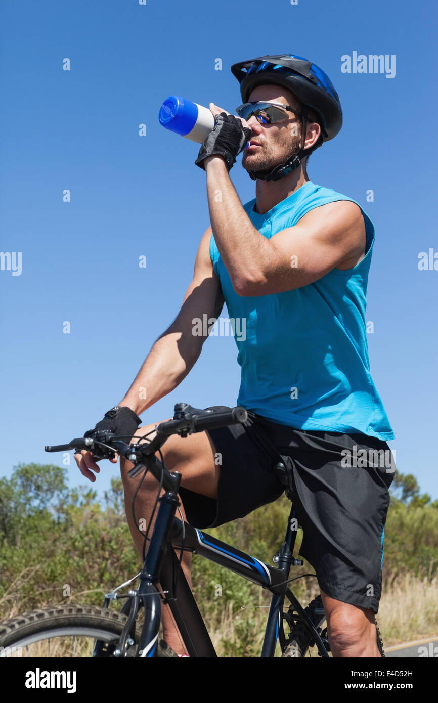 Handsome cyclist taking a break on his bike drinking water Stock Photo ...