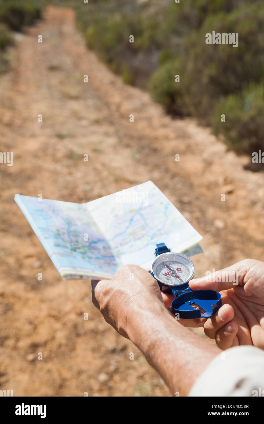 Hiker holding his compass and map in the countryside Stock Photo - Alamy