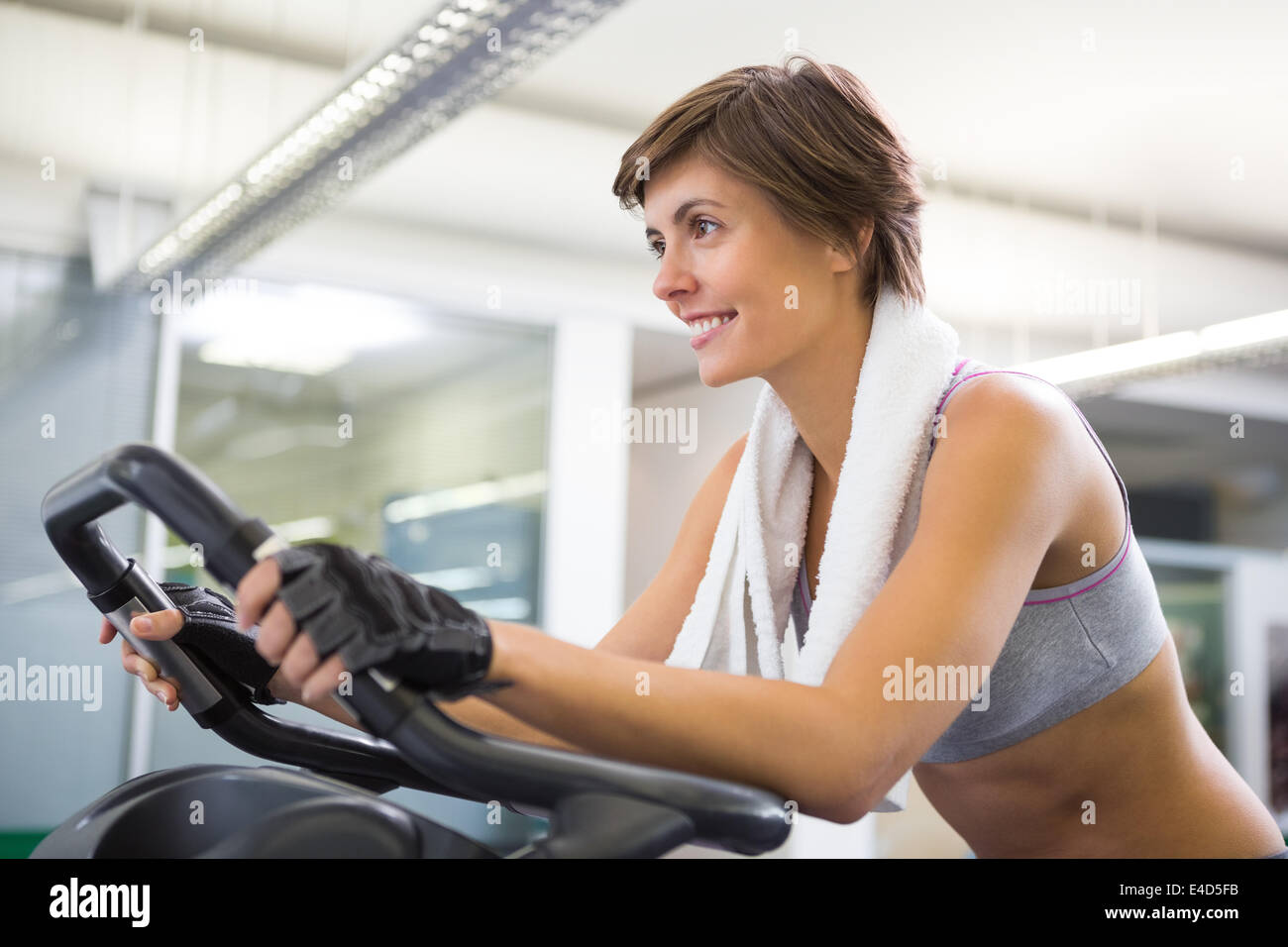 Fit smiling woman working out on the exercise bike Stock Photo - Alamy