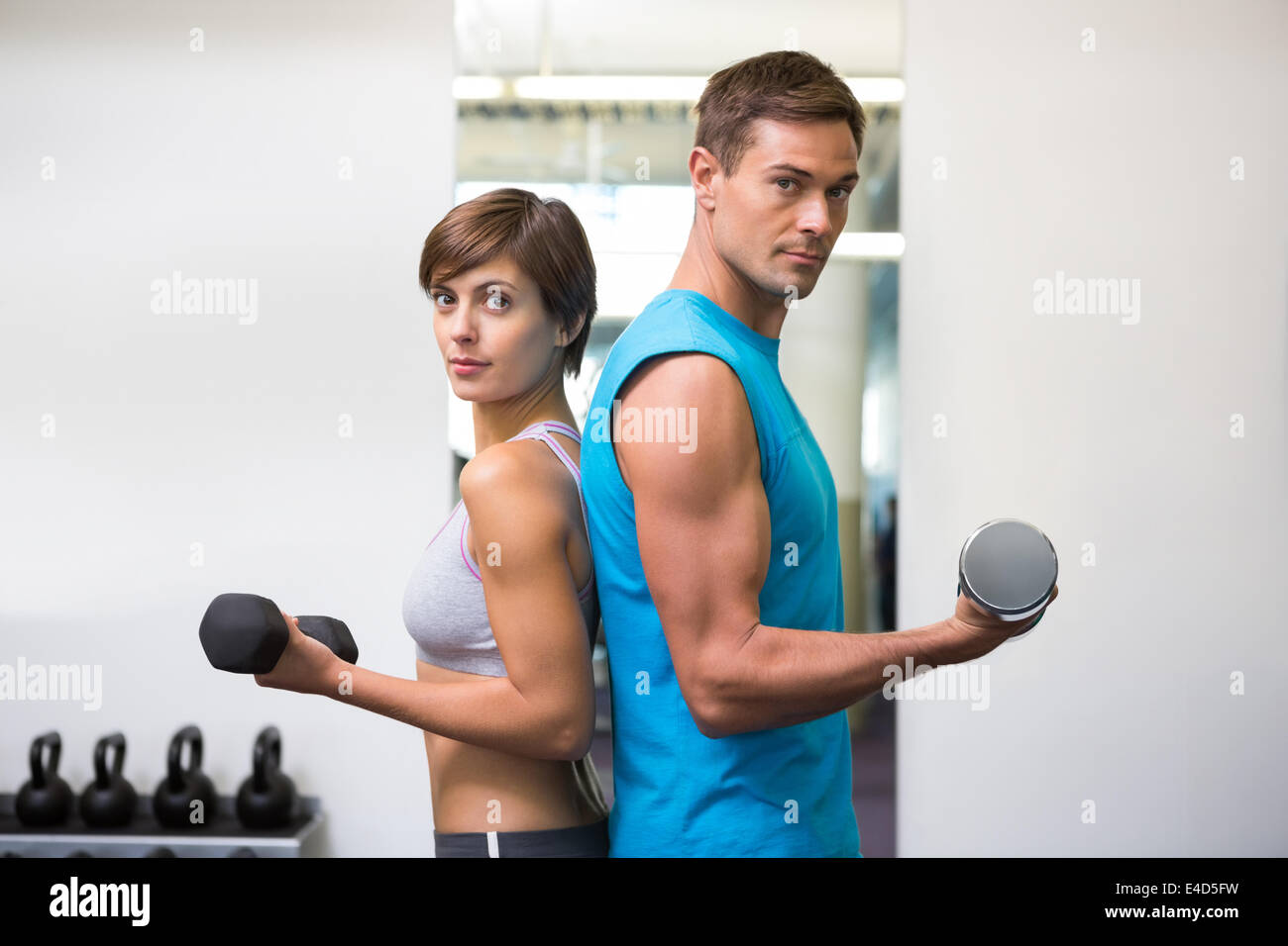 Fit couple lifting dumbbells together Stock Photo - Alamy