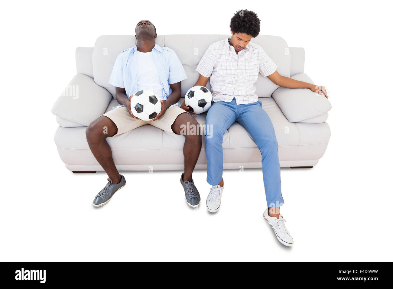 Distraught football fans sitting on the couch with balls Stock Photo ...