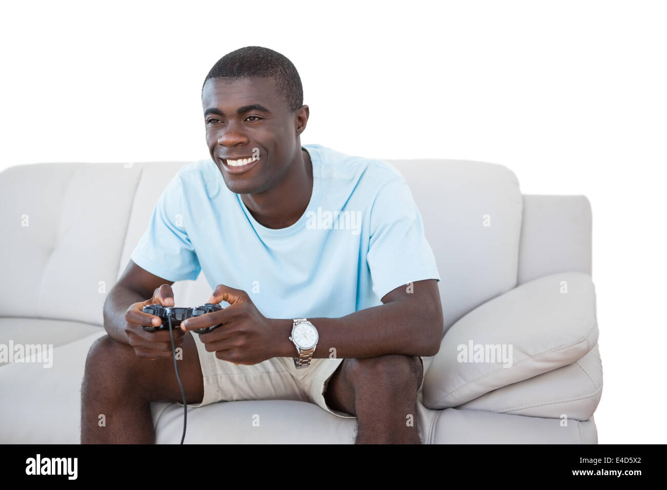 Smiling man sitting on couch playing video games Stock Photo - Alamy