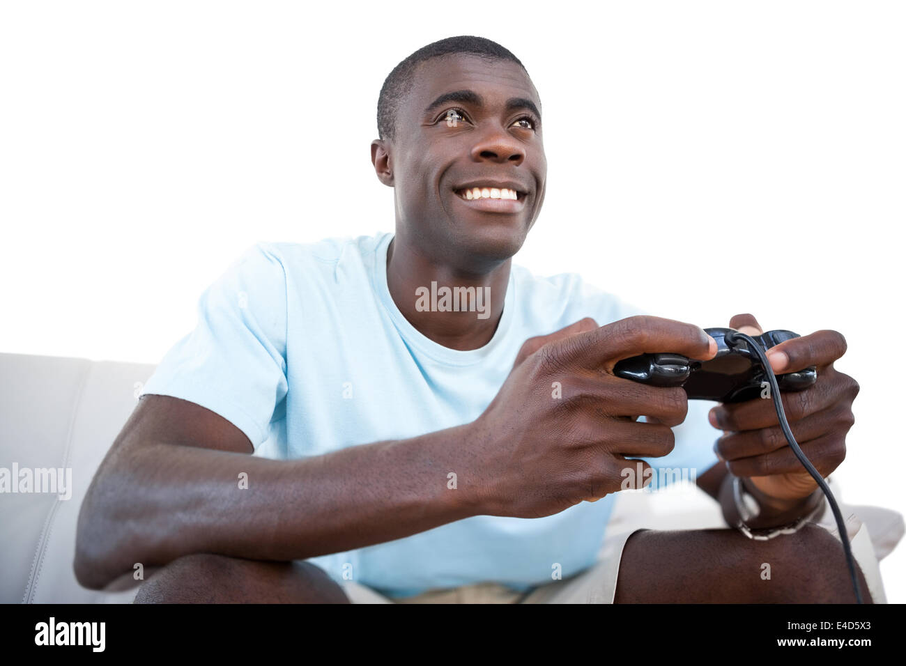 Smiling man sitting on couch playing video games Stock Photo - Alamy