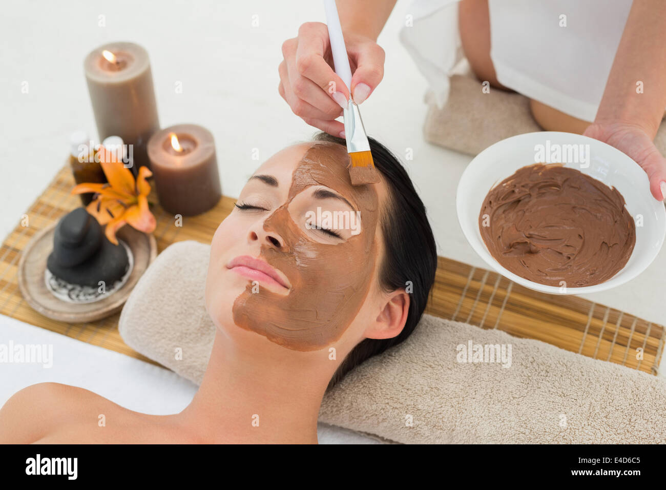 Peaceful brunette getting a mud facial applied Stock Photo - Alamy